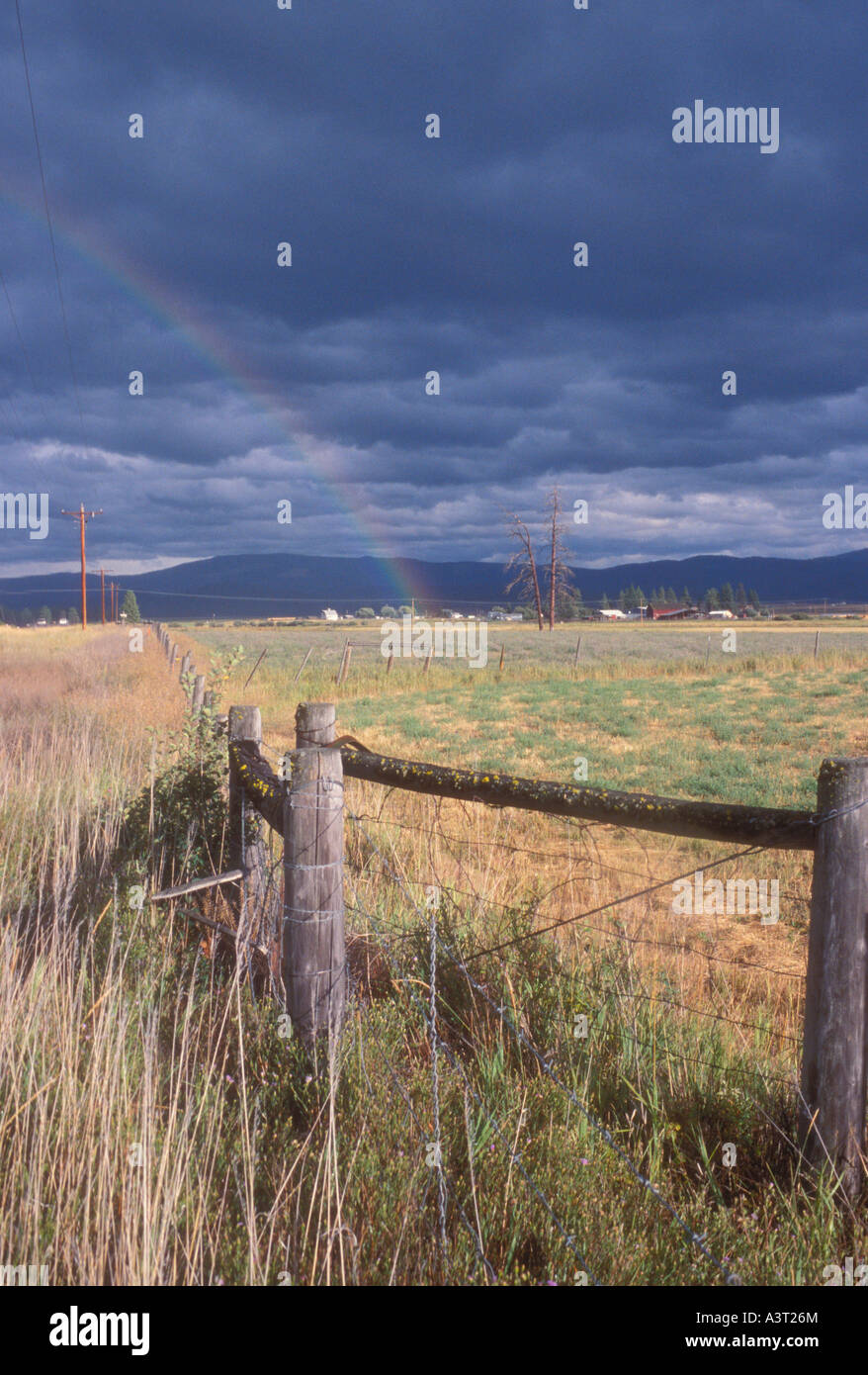 A rainbow arches across the sky above a ranch near Missoula Mont Stock ...