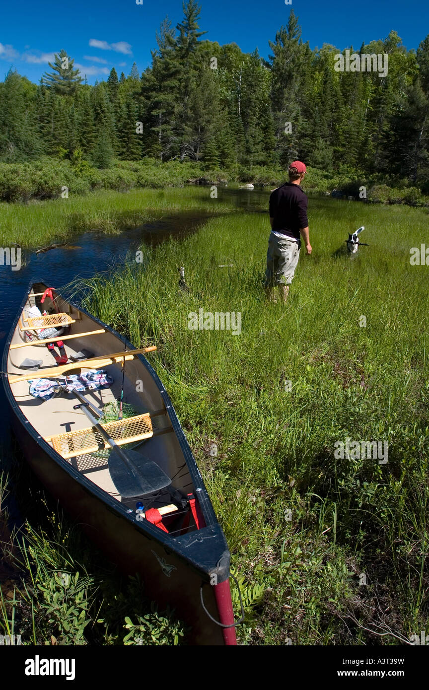 A man plays fetch with a dog while canoeing in Craig Lake State Park ...