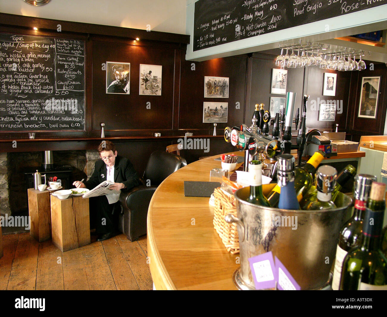 woman reading newspaper in the bar at the Harbourmaster boutique hotel ...