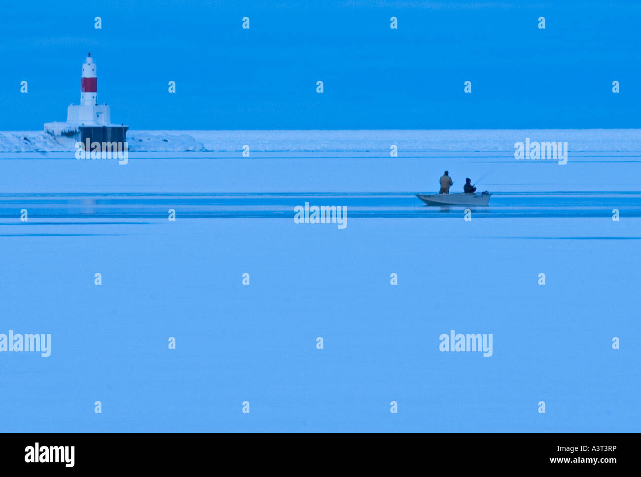 Salmon fishermen fish from a boat in a narrow strip of open water on ...