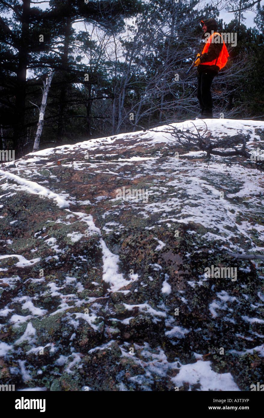 A whitetail deer hunter scouts from a rock outcrop near Marquette ...