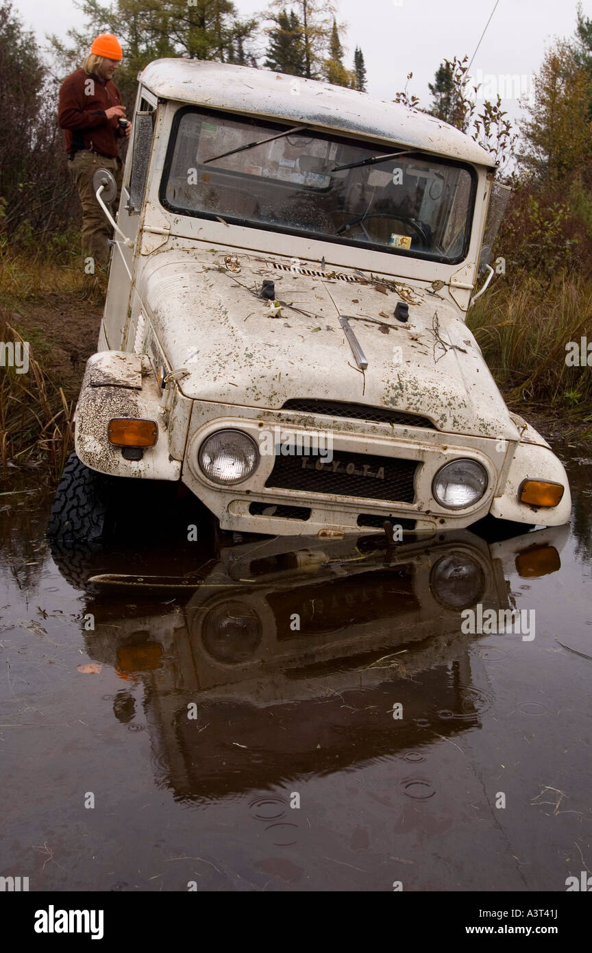 A Toyota Land Cruiser stuck in the mud of a beaver pond during a ...