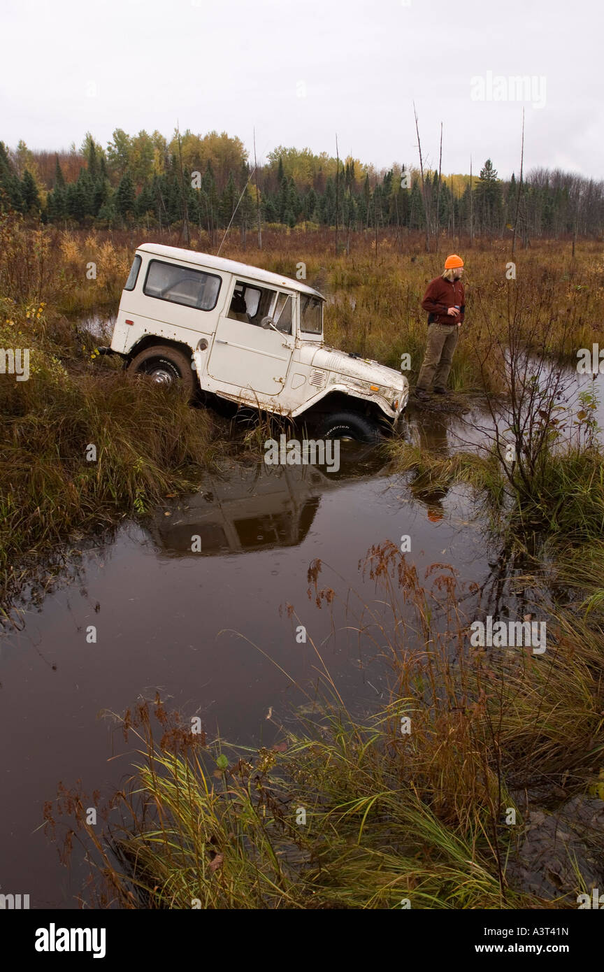A Toyota Land Cruiser stuck in the mud of a beaver pond during a ...
