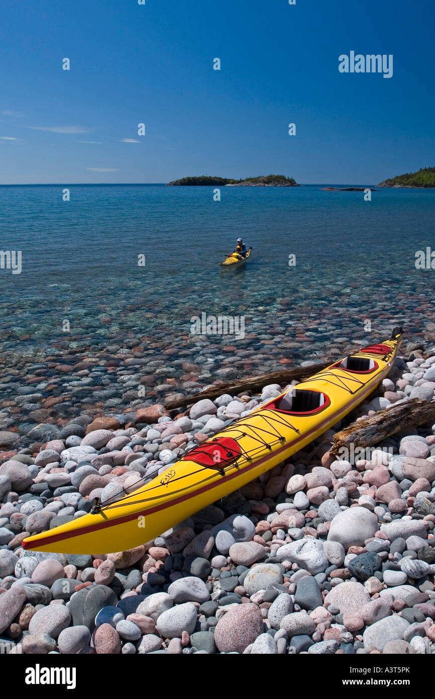 A tandem sea kayak rests on the boulder beach of Gargantua Harbor in ...