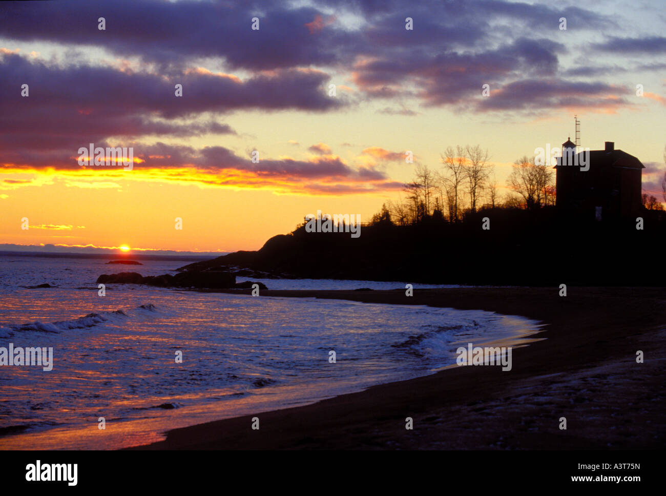 THE MARQUETTE LIGHTHOUSE IS SILHOUETTED AS THE SUN RISES ON LAKE ...