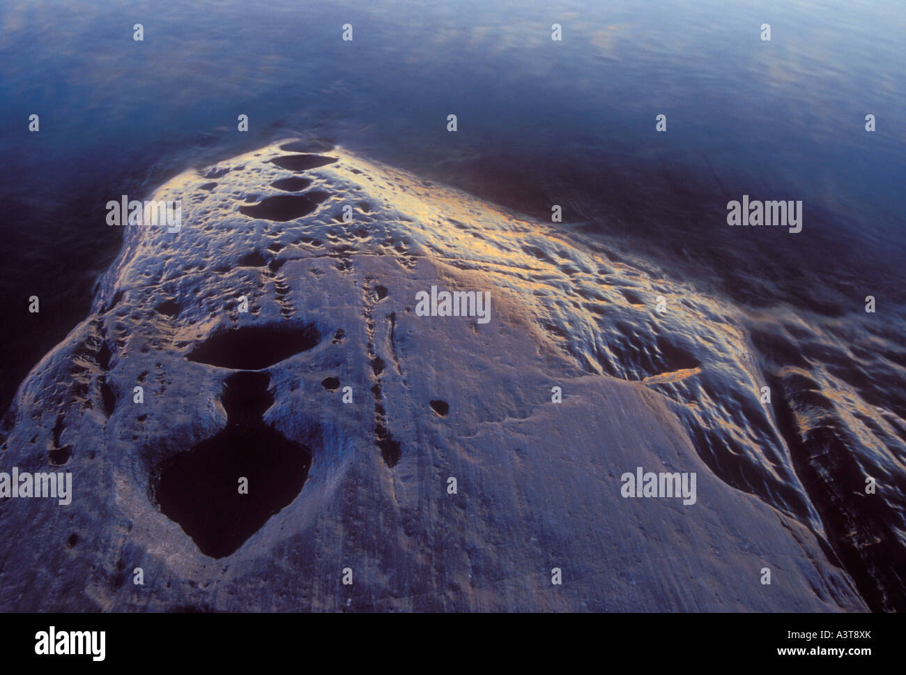 A pockmarked rock on Lake Superior in Pukaskwa National Park near White ...