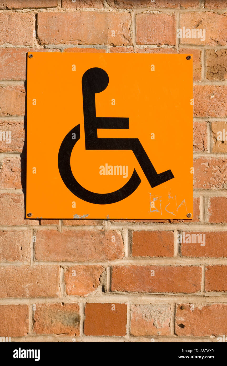 Orange disabled sign on brick wall UK Stock Photo - Alamy