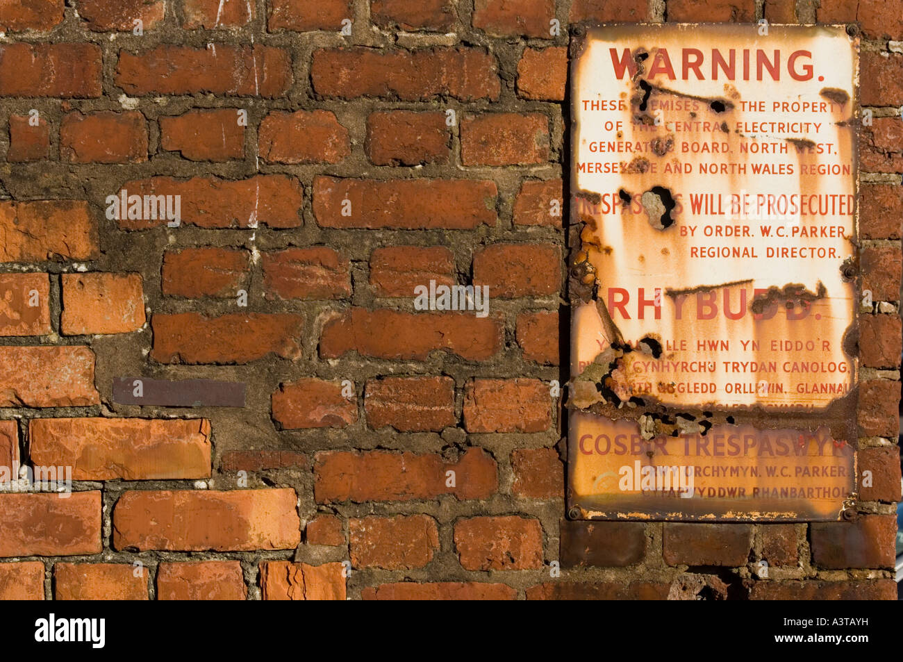 Rusty eroded Warning sign on old brick wall Aberystwyth Wales UK Stock ...