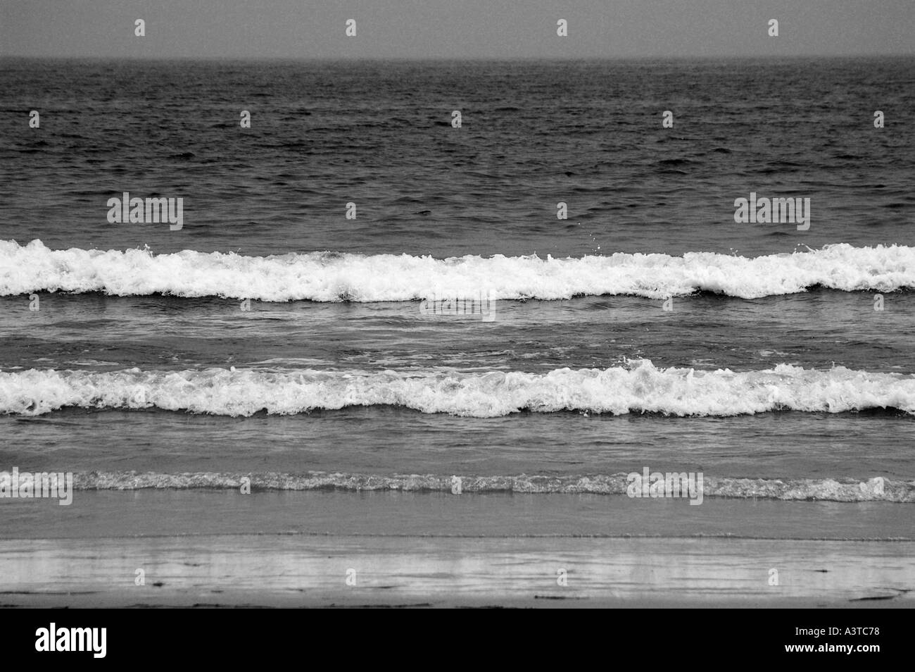 waves crashing on a beach two rows with sky and sea Stock Photo - Alamy