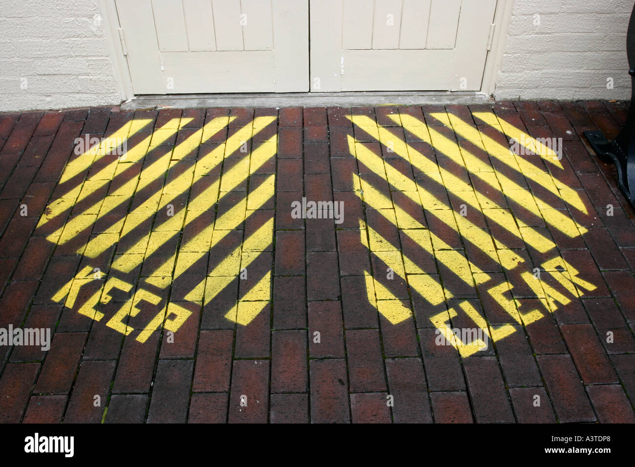 Keep clear diagonal yellow lines on the pavement outside a fire exit ...