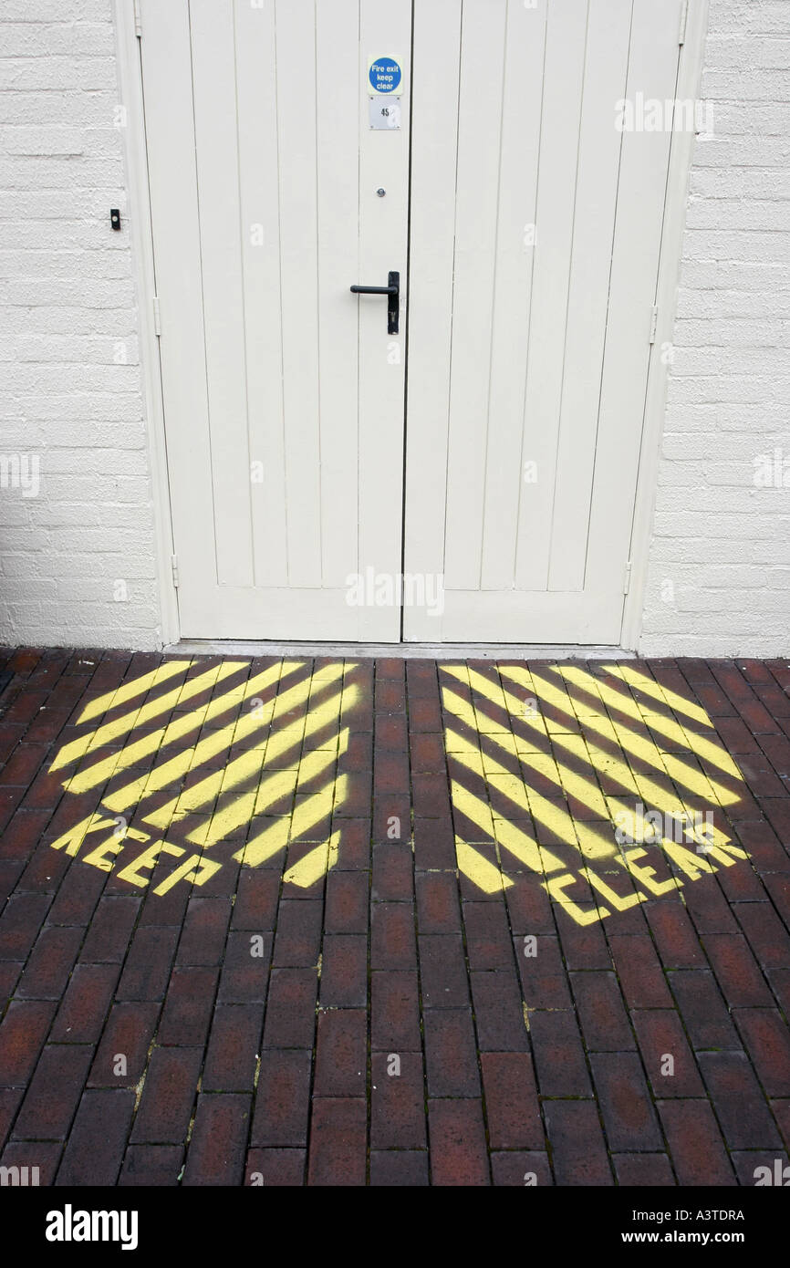 Keep clear diagonal yellow lines on the pavement outside a fire exit ...