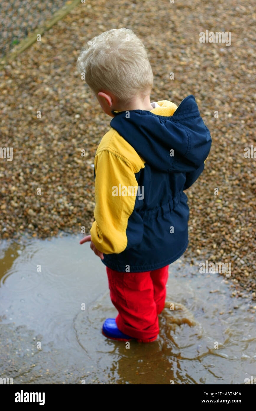 Child Playing in a puddle on gravel path puddle splash play playing ...
