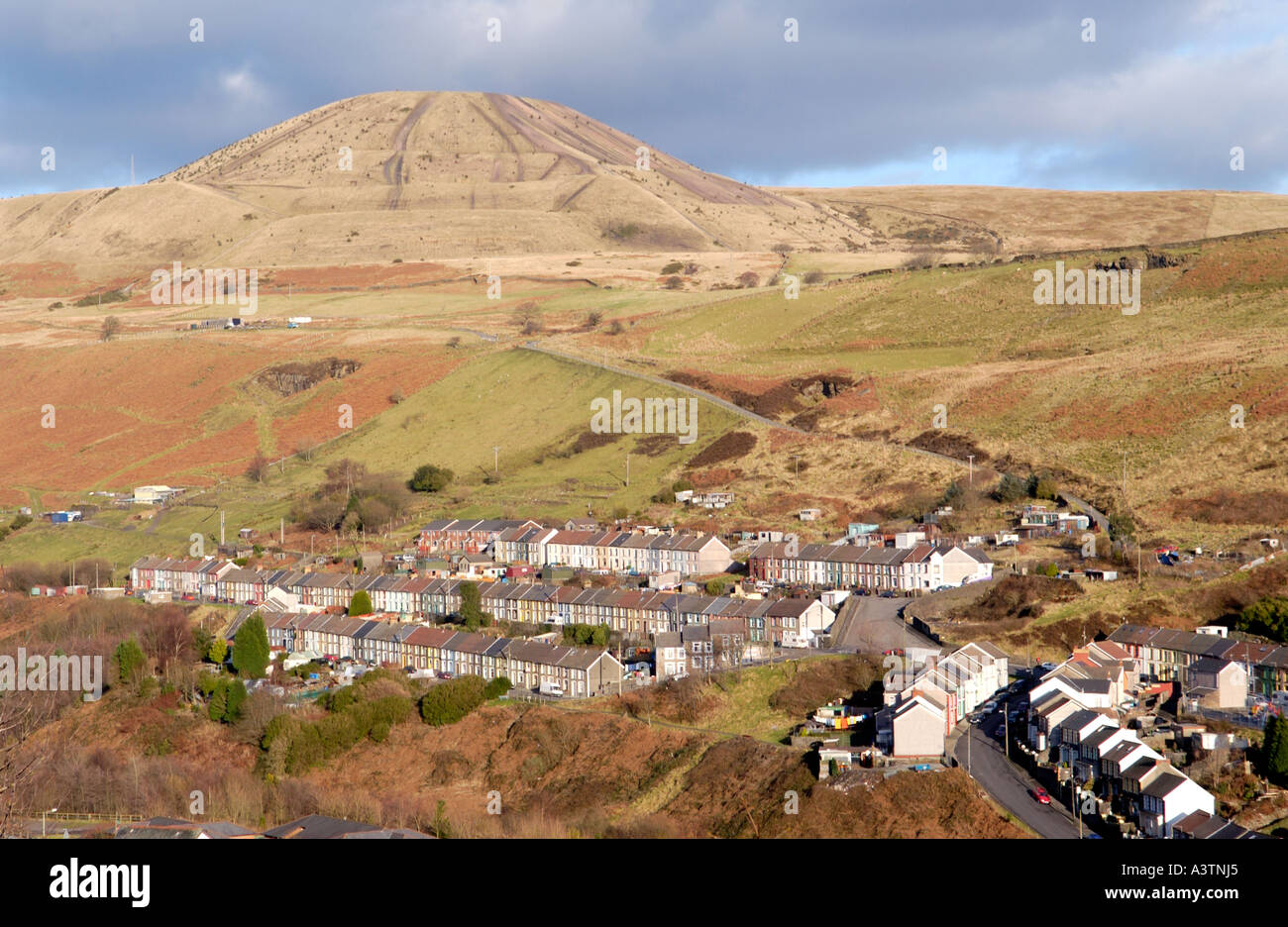 Terraced houses built to house colliery workers with coal tip above at ...
