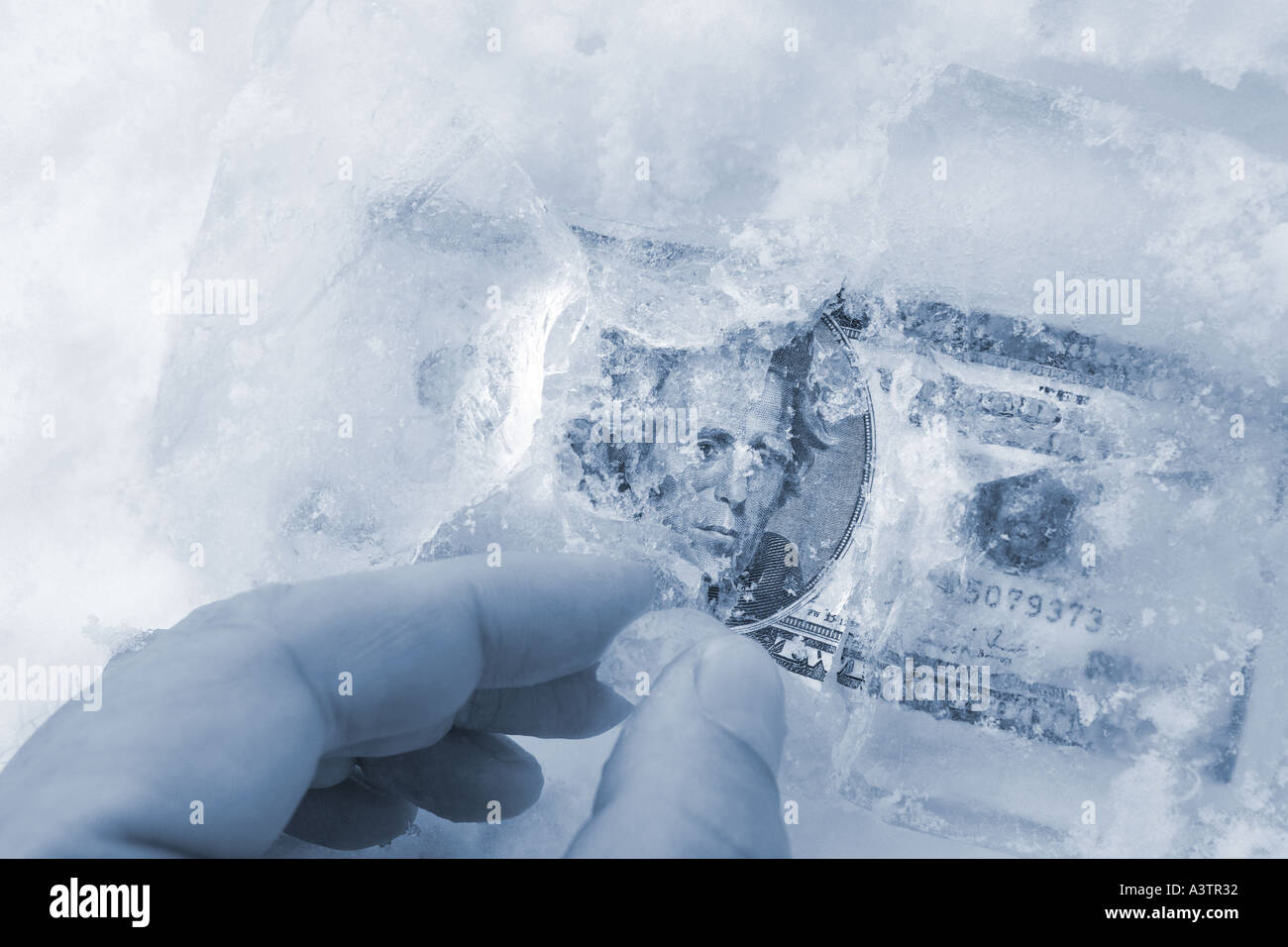 Hand finding frozen money in ice Stock Photo - Alamy
