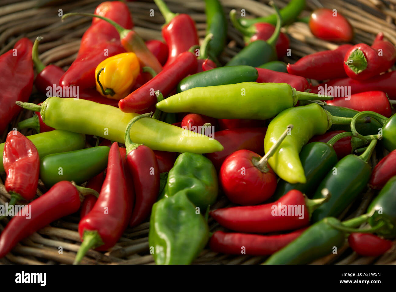 Mixed chillis in a basket Stock Photo - Alamy