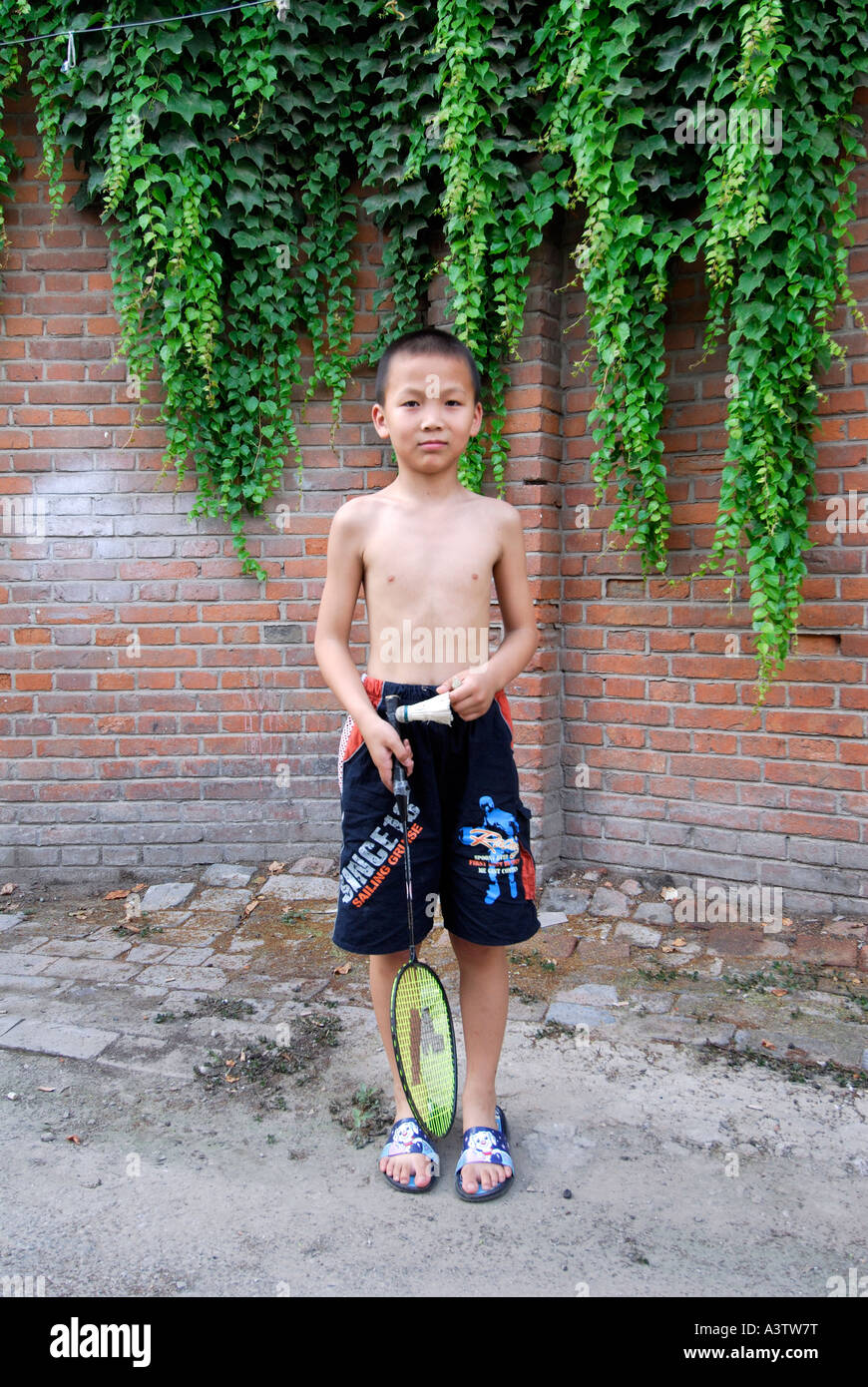 Chinese boy playing badminton in the streets of Beijing Hutong China ...
