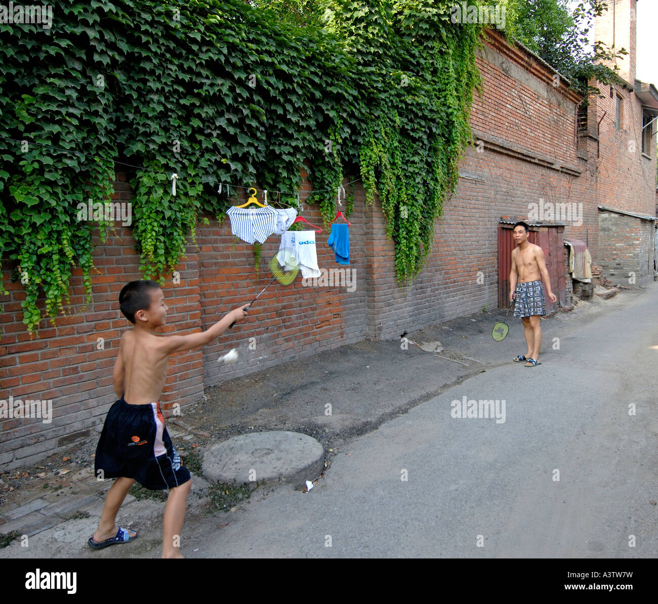Chinese boys playing badminton in the streets of Beijing Hutong China ...