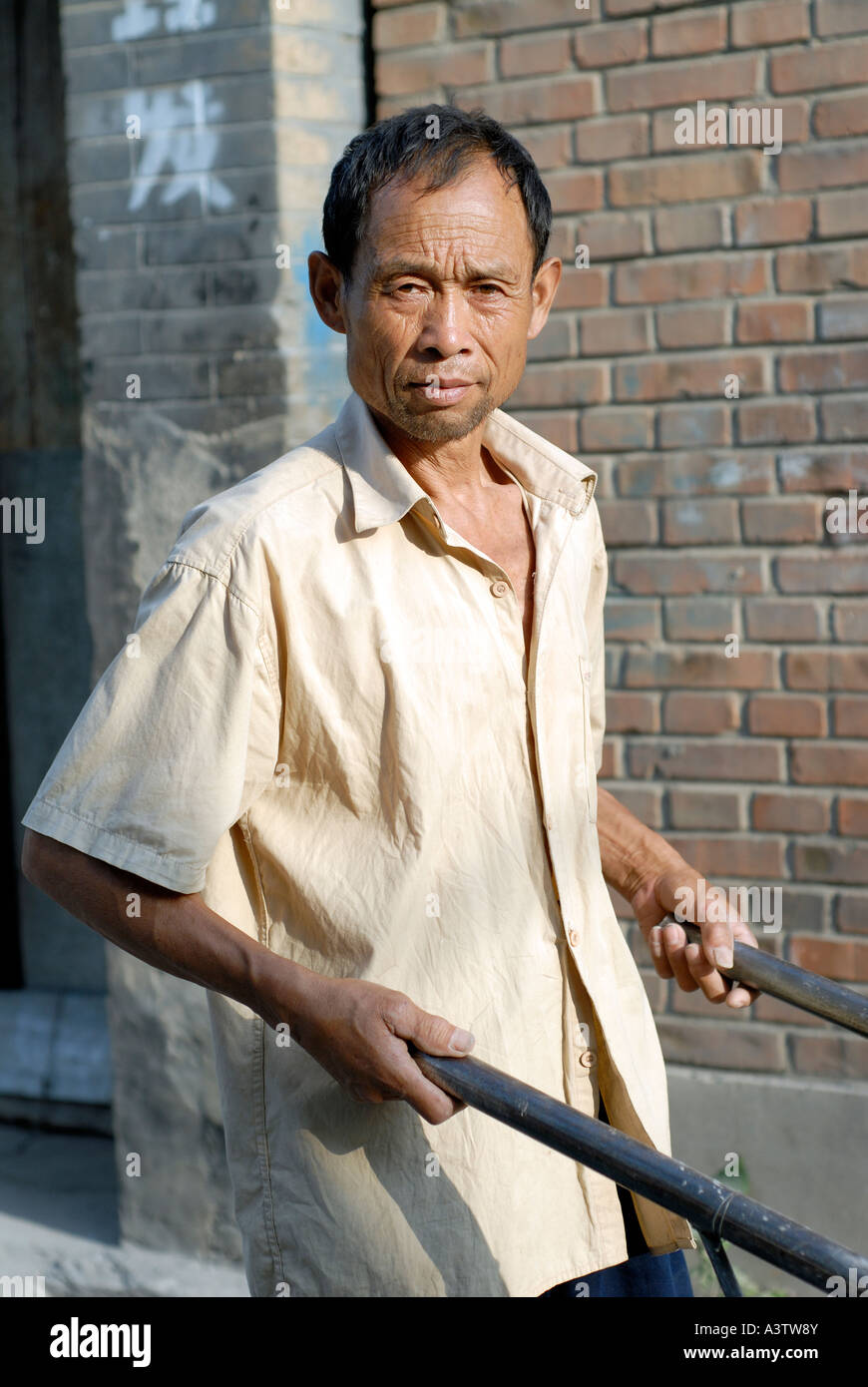Elderly Chinese man working in the streets of Beijing Hutong China ...