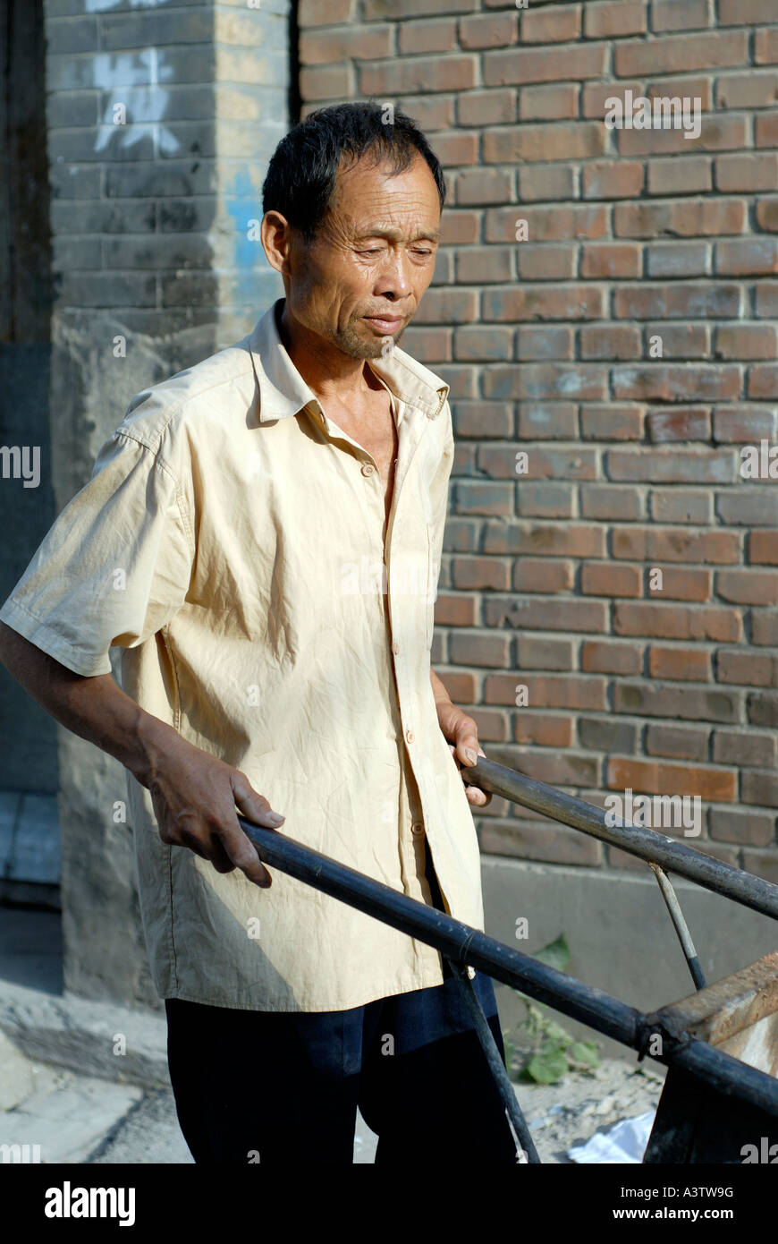 Elderly Chinese man working in the streets of Beijing Hutong China ...