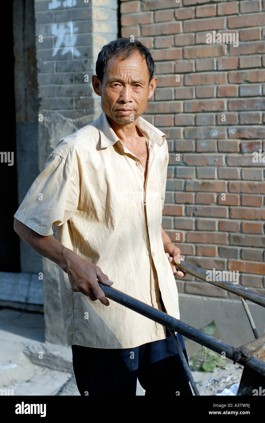 Elderly Chinese man working in the streets of Beijing Hutong China ...