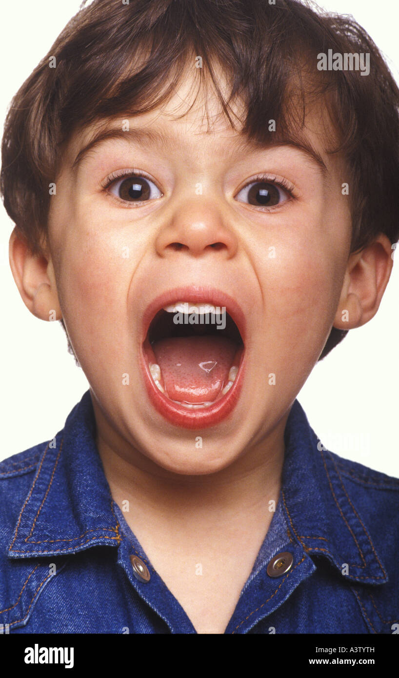 Young boy dark hair screaming with blue shirt and white background ...