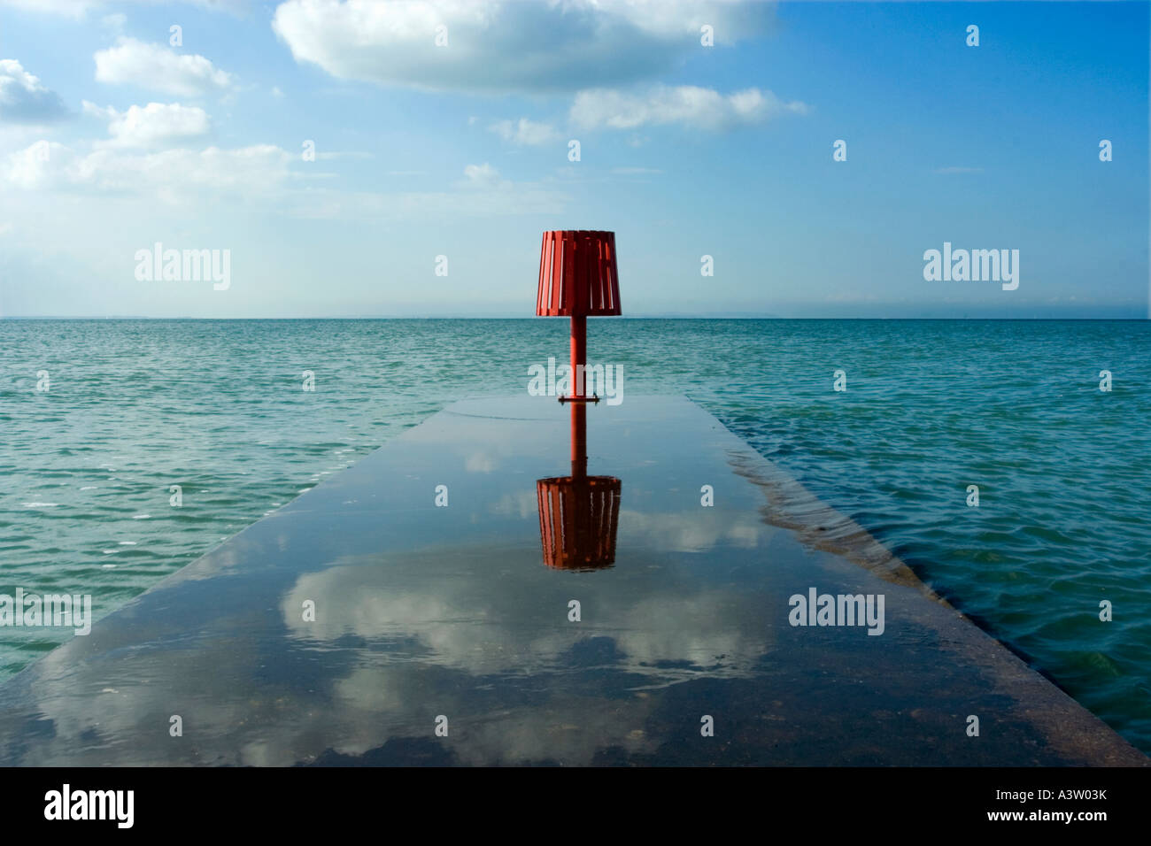 Red jetty marker , sea and reflections of sky Stock Photo - Alamy
