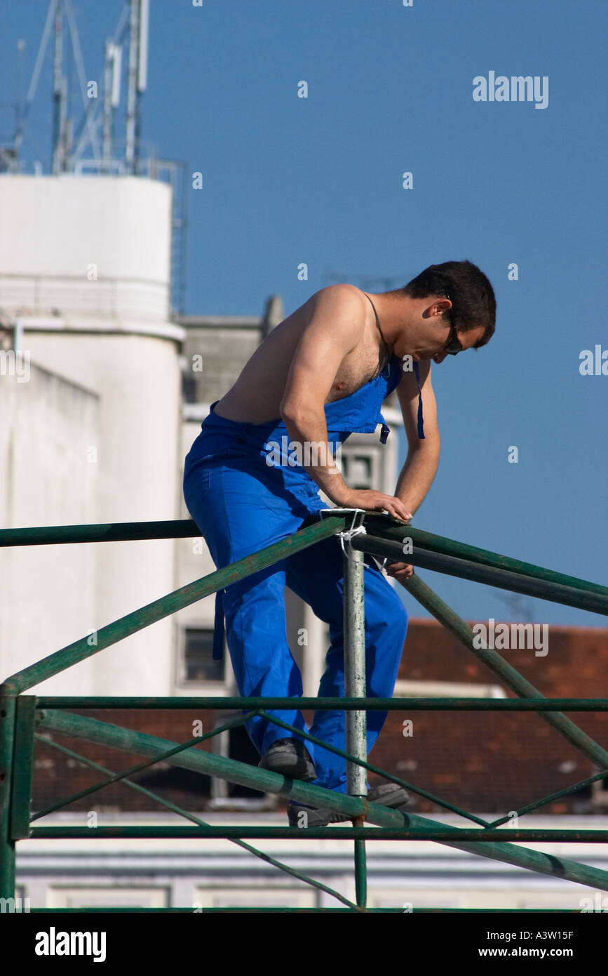 worker sitting on scaffold Stock Photo - Alamy