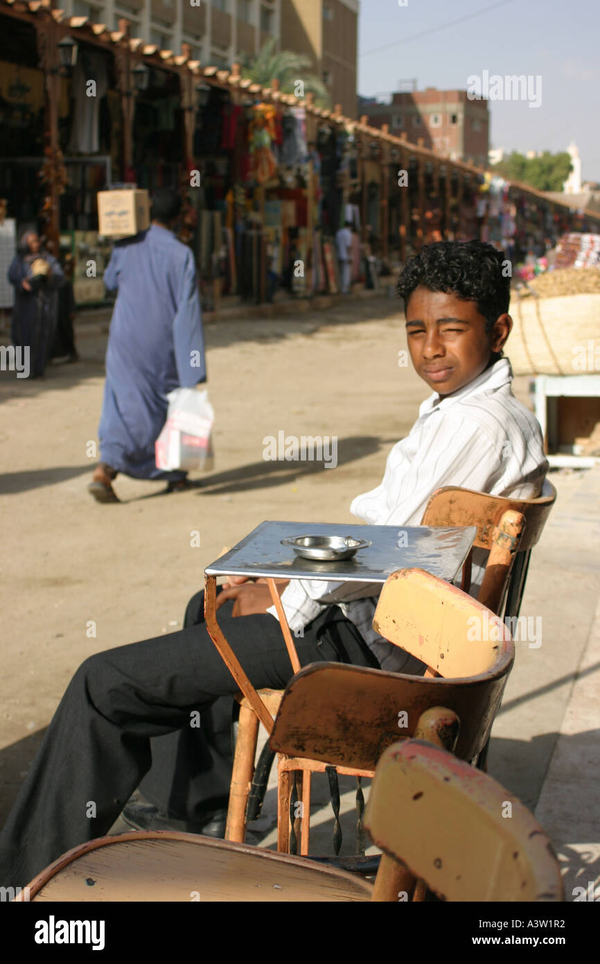 Young egyptian boy sitting in cafe on the market street, Aswan, Egypt ...