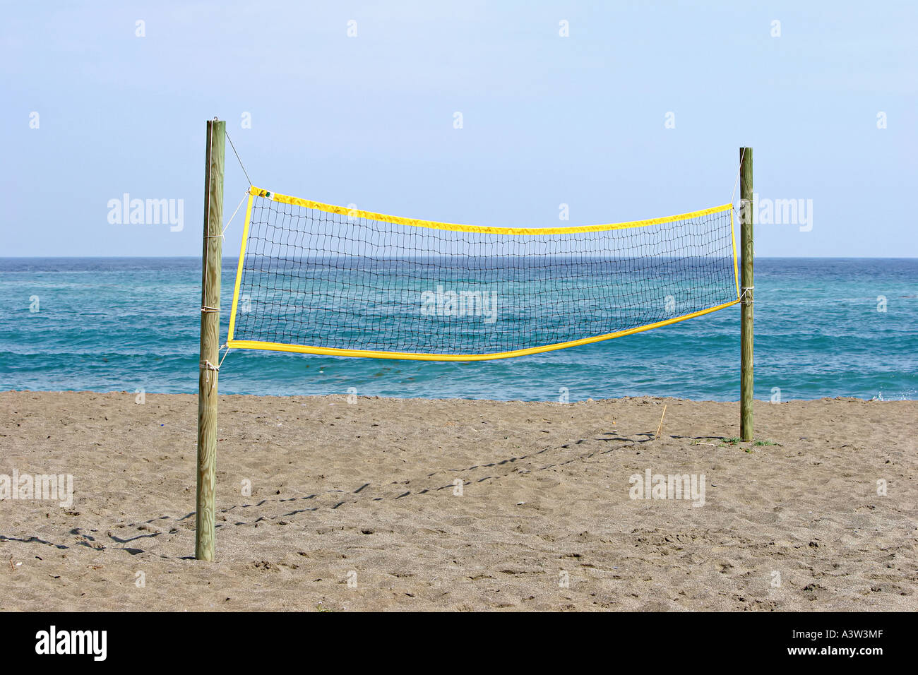 Yellow volleyball net on sunny sandy beach in Spain Stock Photo - Alamy