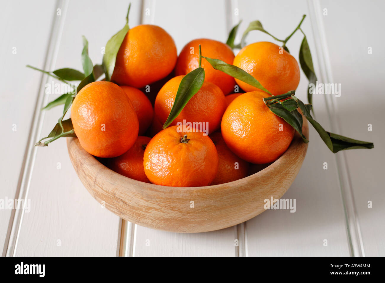 Bowl of clementines with leaves on wooden table Stock Photo - Alamy