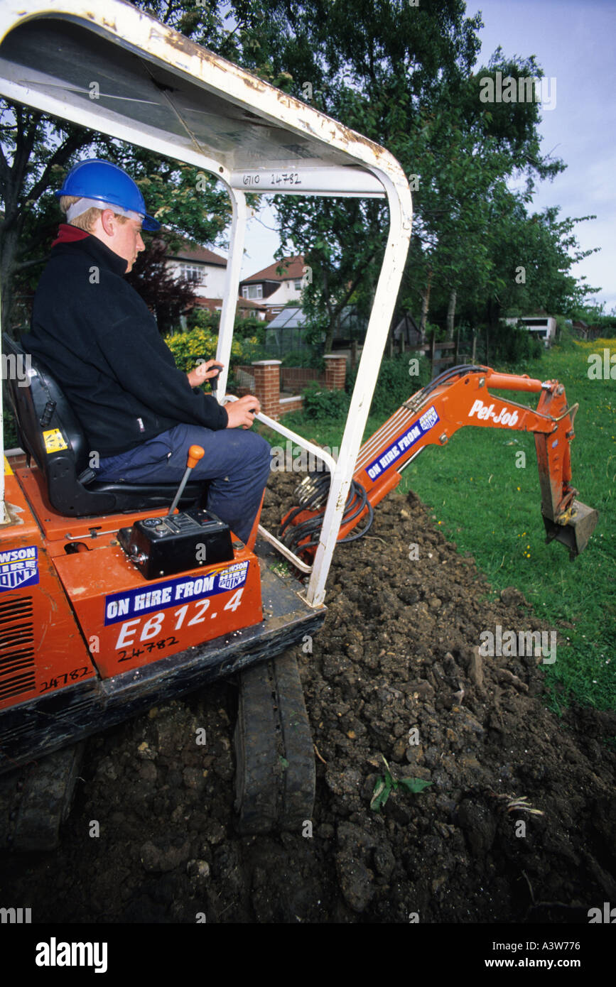 workman operating digger on site in leeds yorkshire uk Stock Photo - Alamy