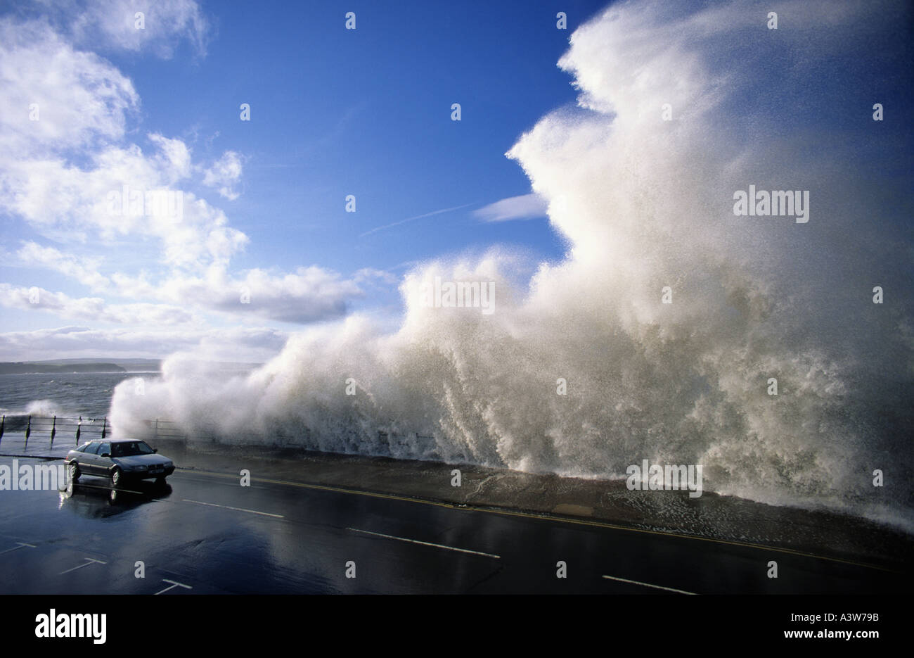 giant wave crashing over sea defences and car on the marine drive ...