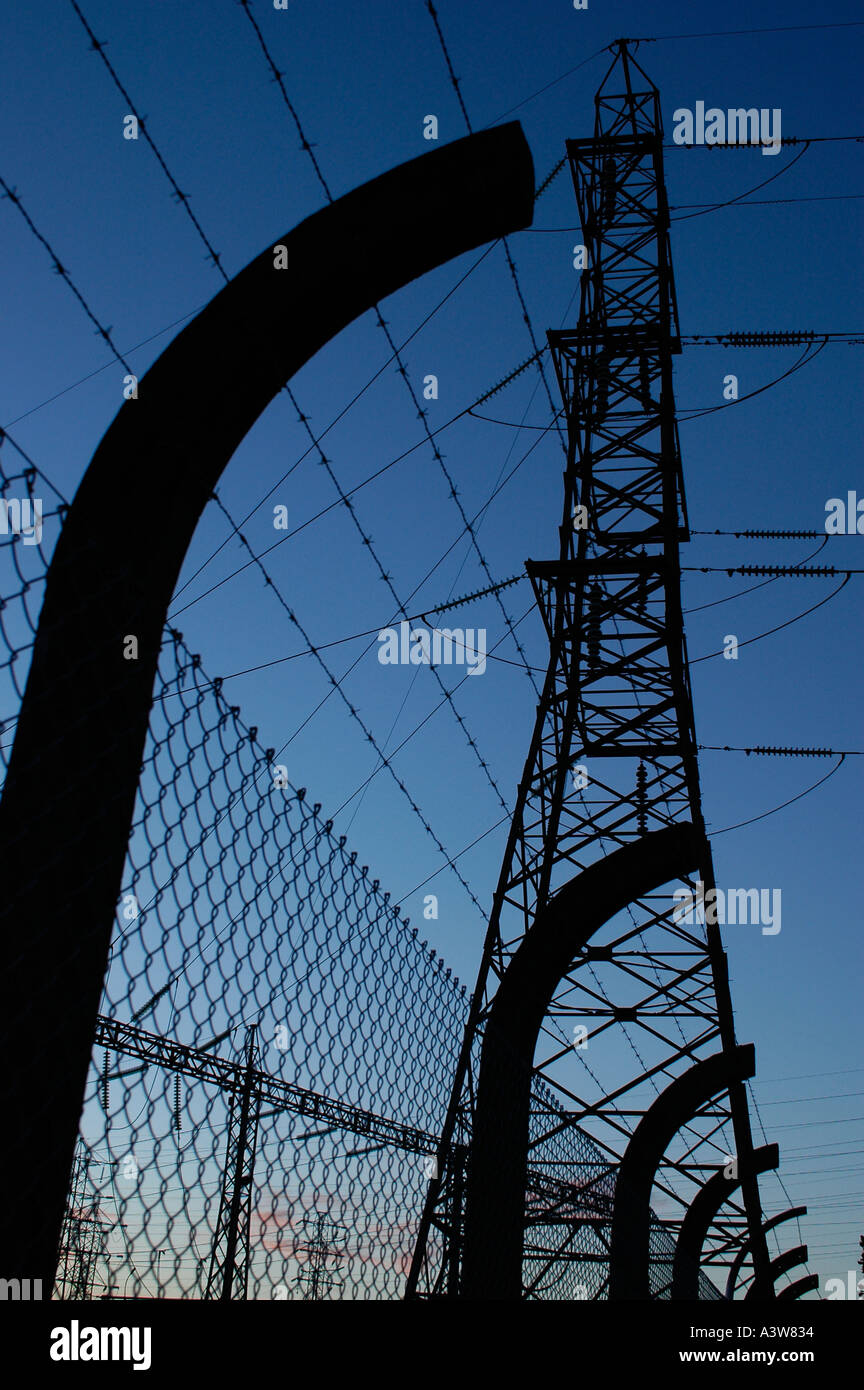 Electrical power pylon behind a barbed wire security fence in a sub ...