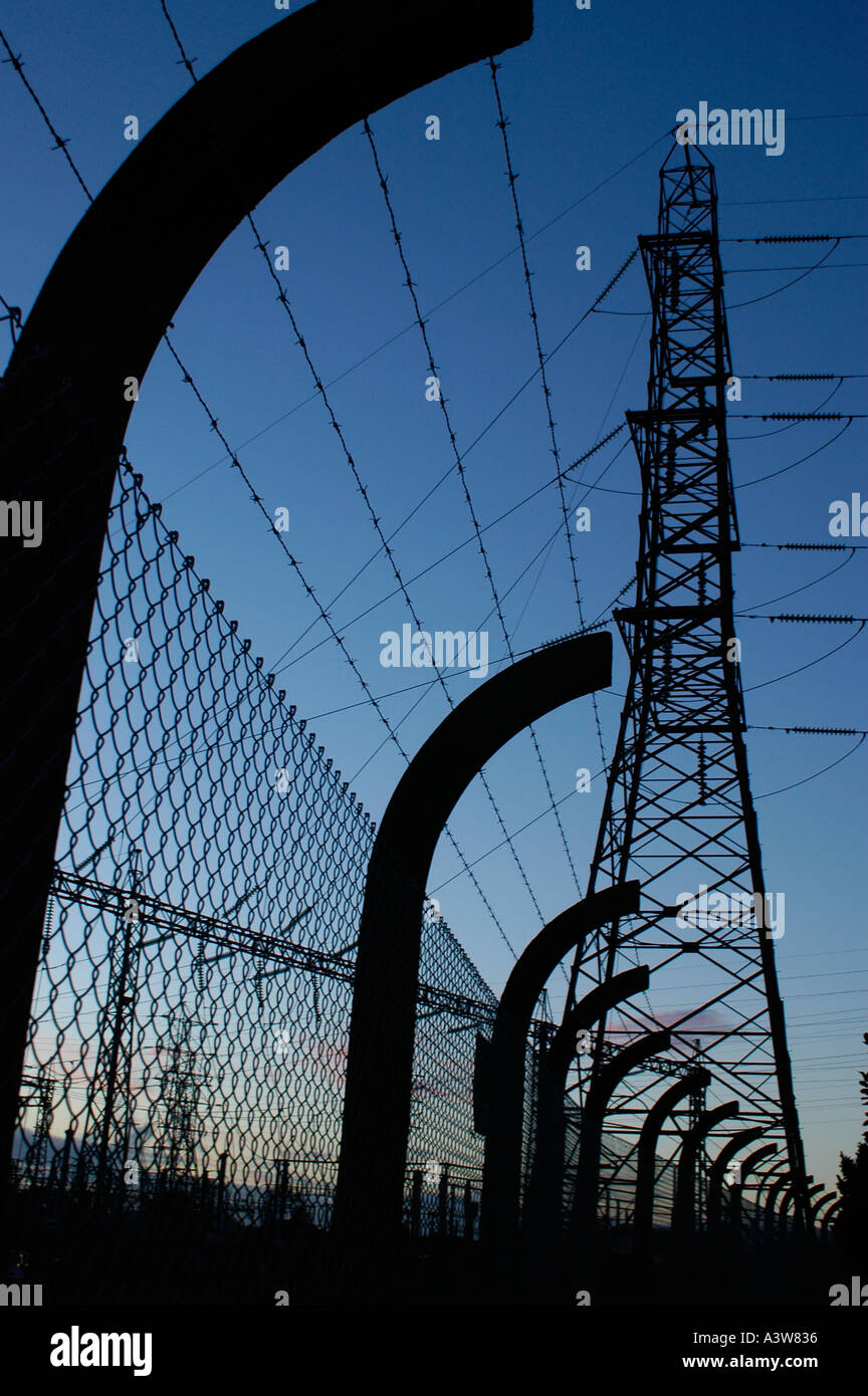 Electrical power pylon behind a barbed wire security fence in a sub ...