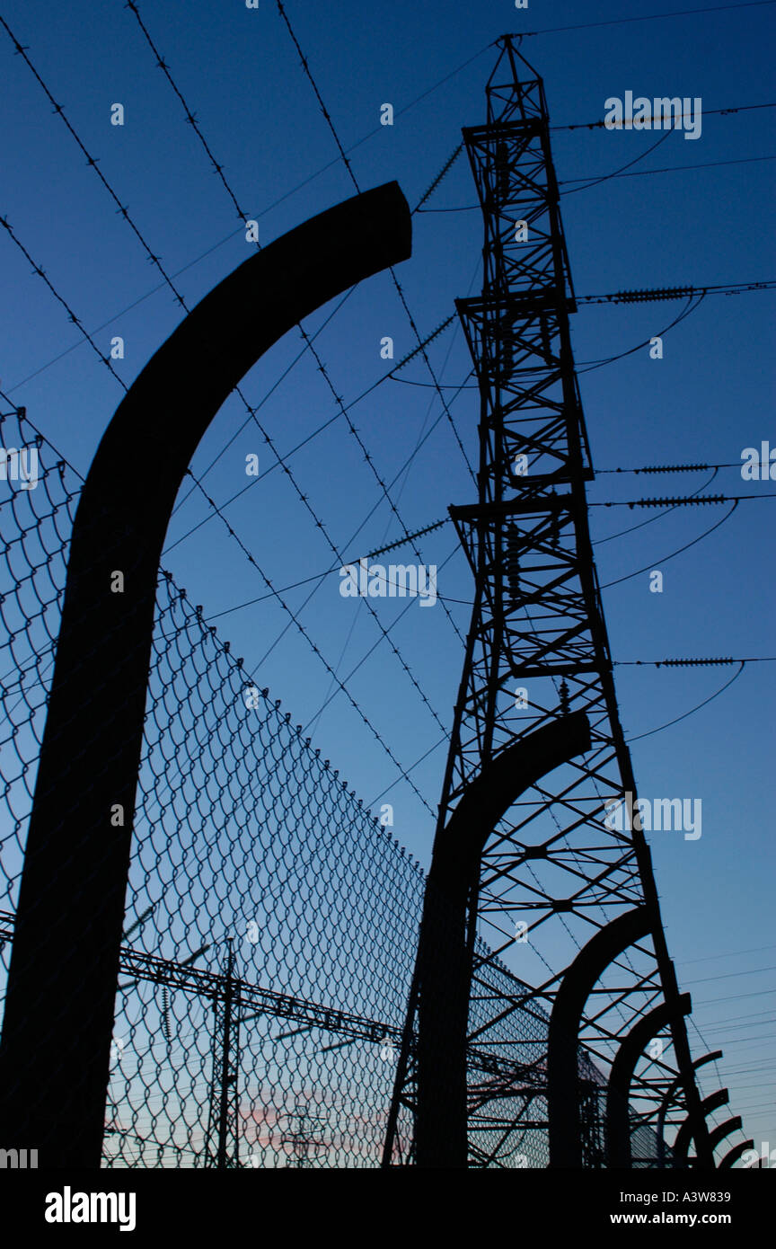 Electrical power pylon behind a barbed wire security fence in a sub ...