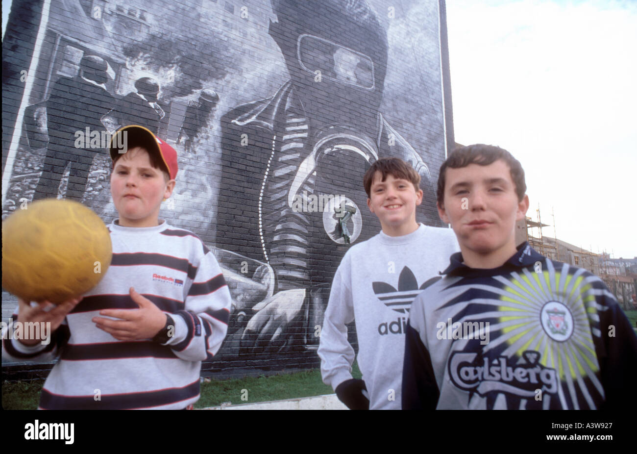 Idle kids infront of mural of the troubles in Londonderry Northern ...