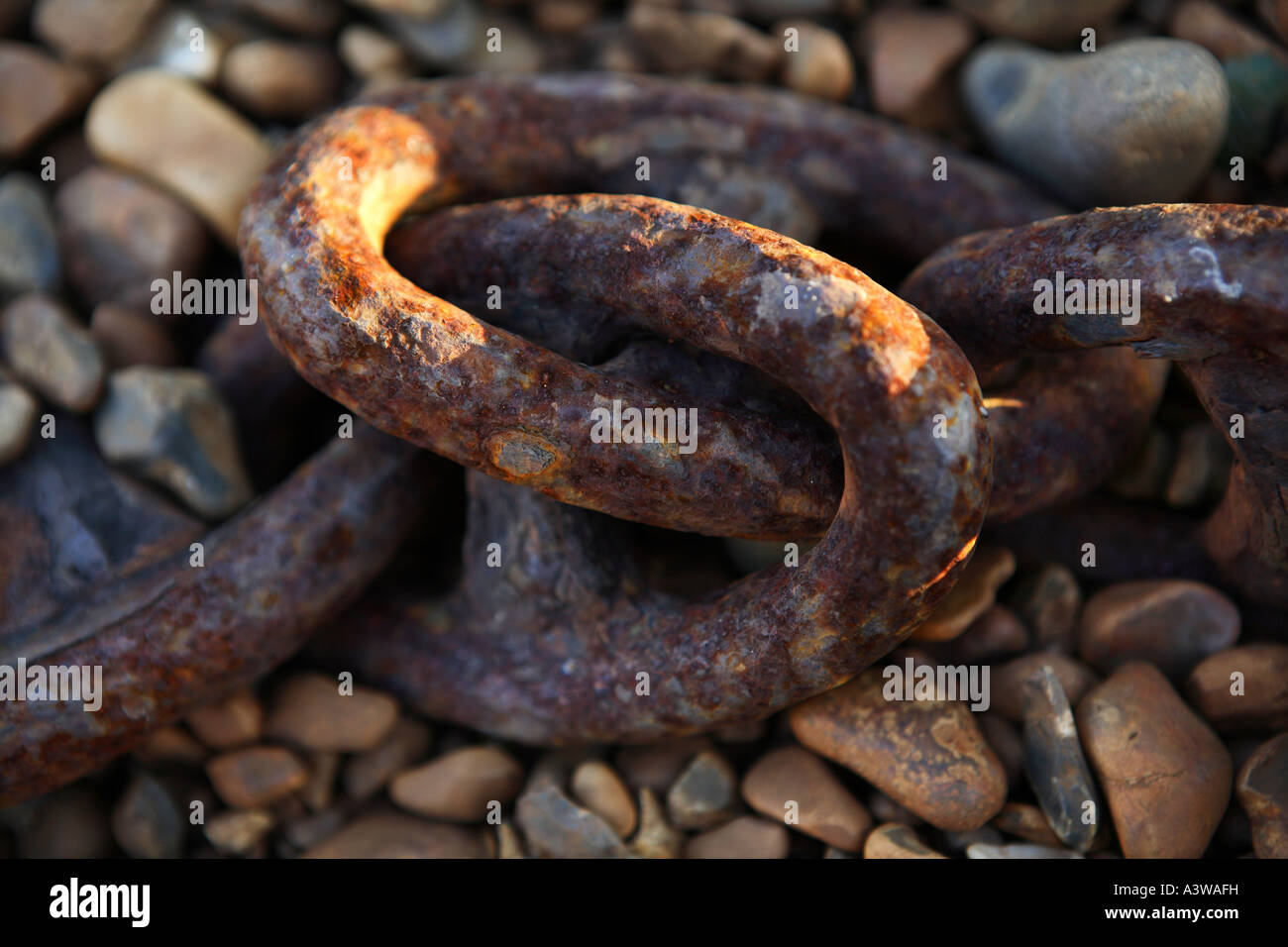 Rusty chain on a pebble beach Stock Photo - Alamy