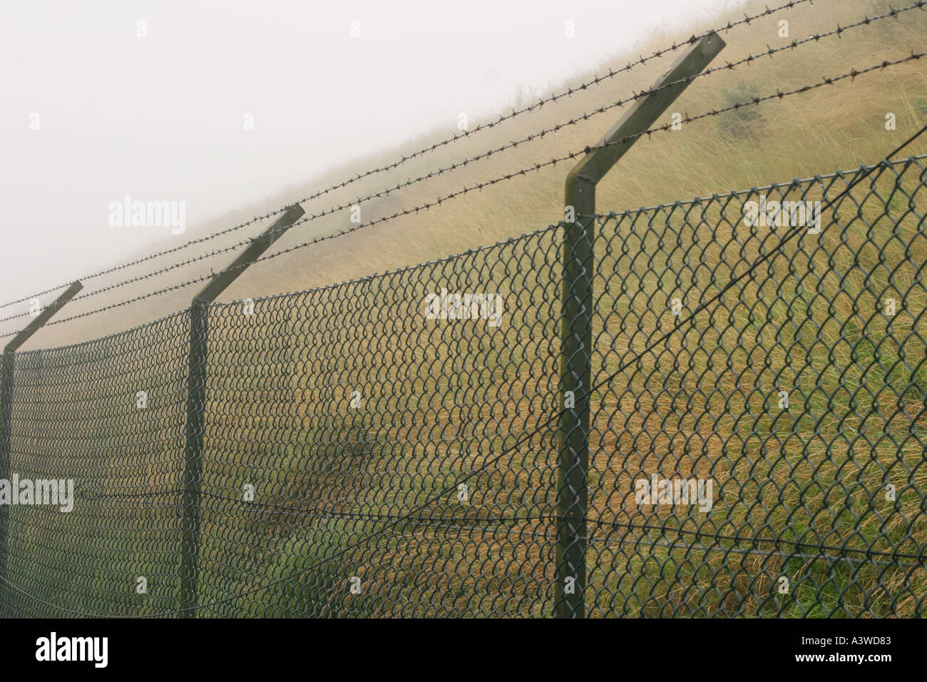 Barbed wire perimeter fence Stock Photo - Alamy