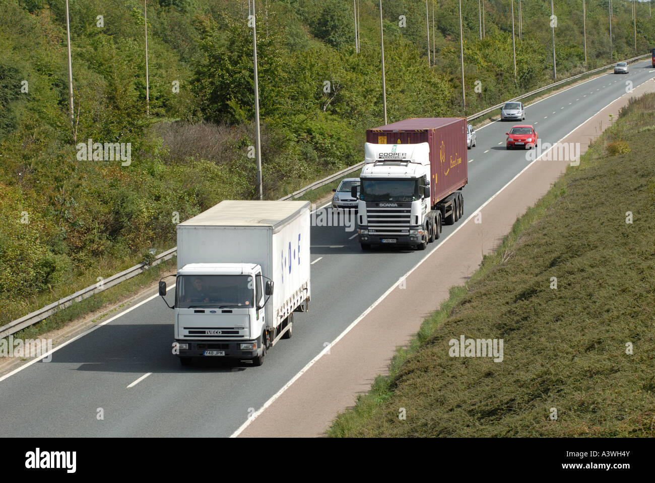 Lorries and cars driving along a dual carriageway in the UK Stock Photo ...
