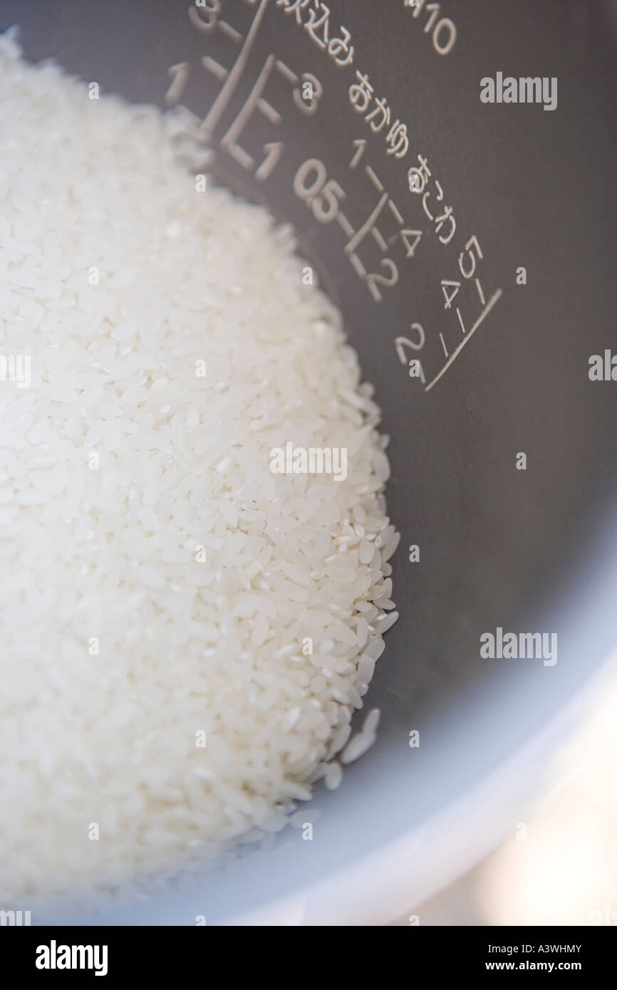measuring white rice in rice cooker Stock Photo - Alamy