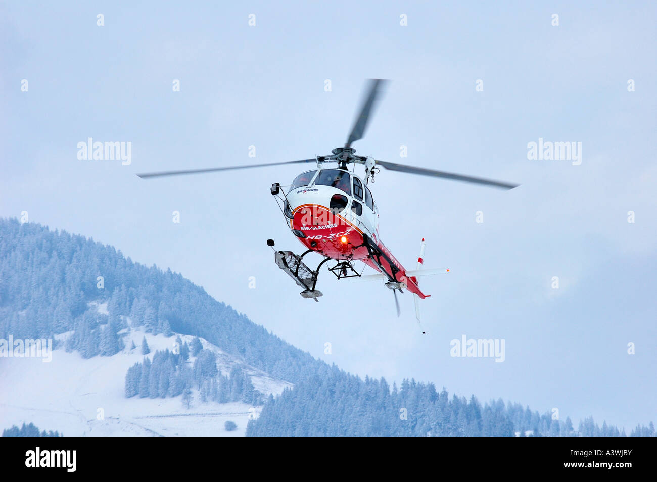 A rescue helicopter landing in the snow-covered Swiss alps Stock Photo ...