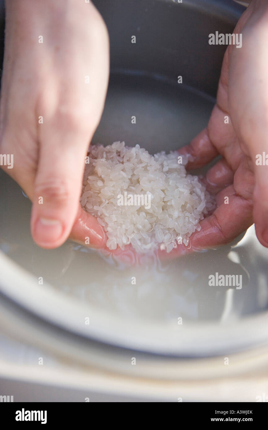 vertical shot of hands washing rice in rice cooker Stock Photo - Alamy