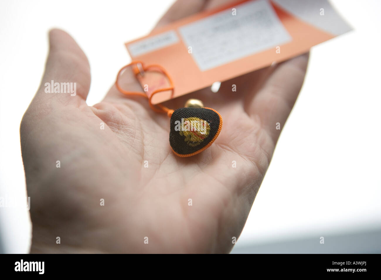 Japanese good luck charm with bell in palm of hand Stock Photo - Alamy