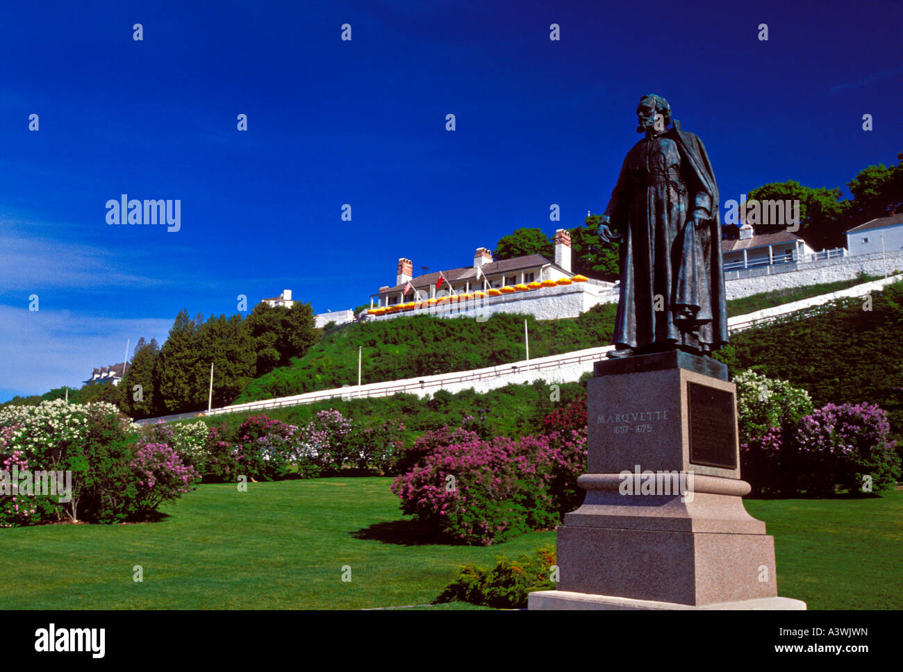 STATUE OF FATHER JACQUES MARQUETTE STANDS AMON BLOOMING LILACS ON THE ...