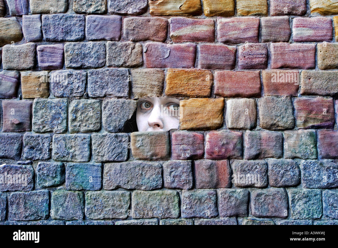 girl looking through hole in wall Stock Photo - Alamy