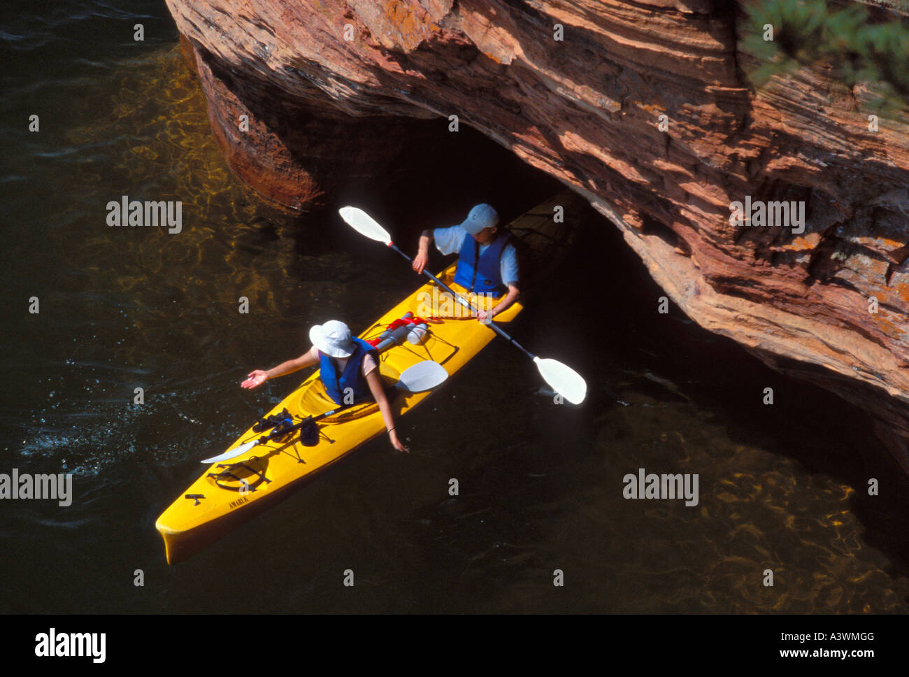KAYAKERS IN A TANDEM KAYAK EXIT A SEA CAVE AT SQUAW POINT IN THE ...