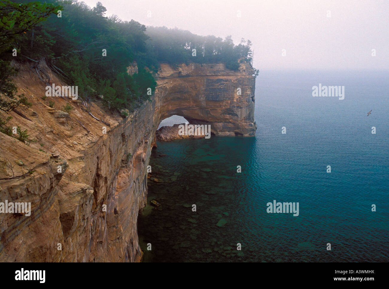 The Grand Portal rock formationin the fog at Pictured Rocks National ...