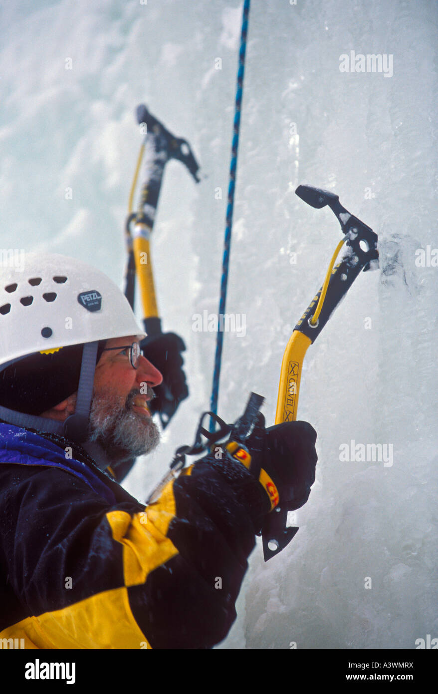 An ice climber claws his way up a frozen waterfall at Pictured Rocks ...