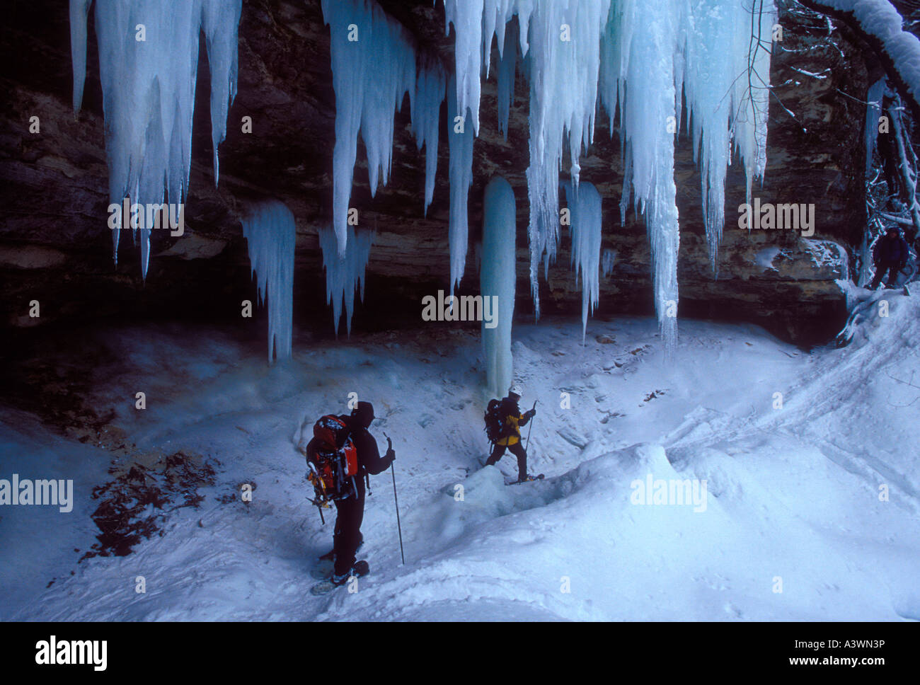 Ice climbers pass cliffs and ice formations in Pictured Rocks National ...