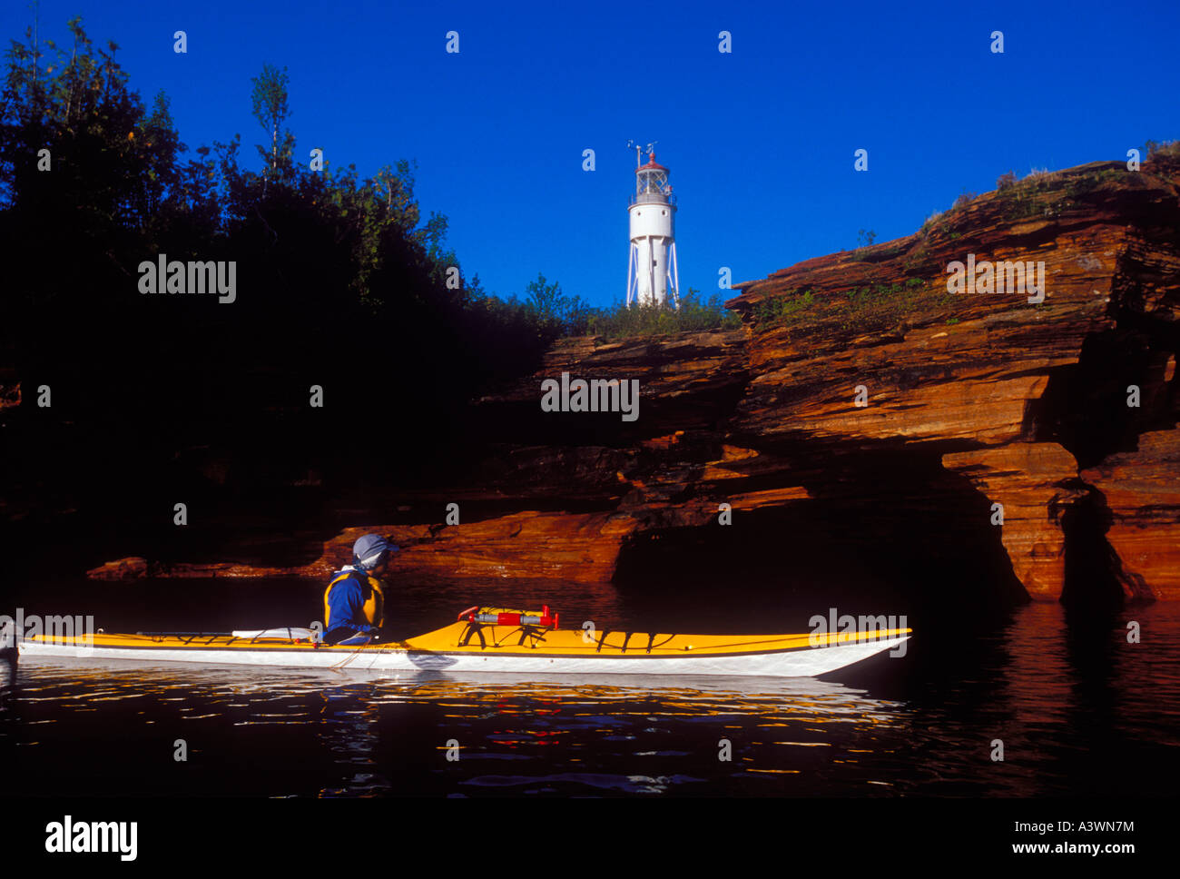 A kayaker paddles below Devils Island Lighthouse on Devils Island in ...